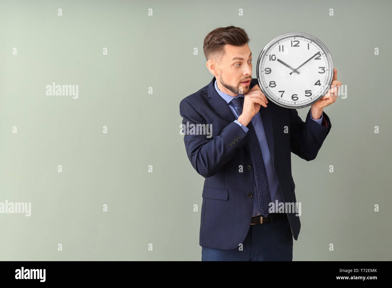 Businessman with clock on color background. Time management concept ...