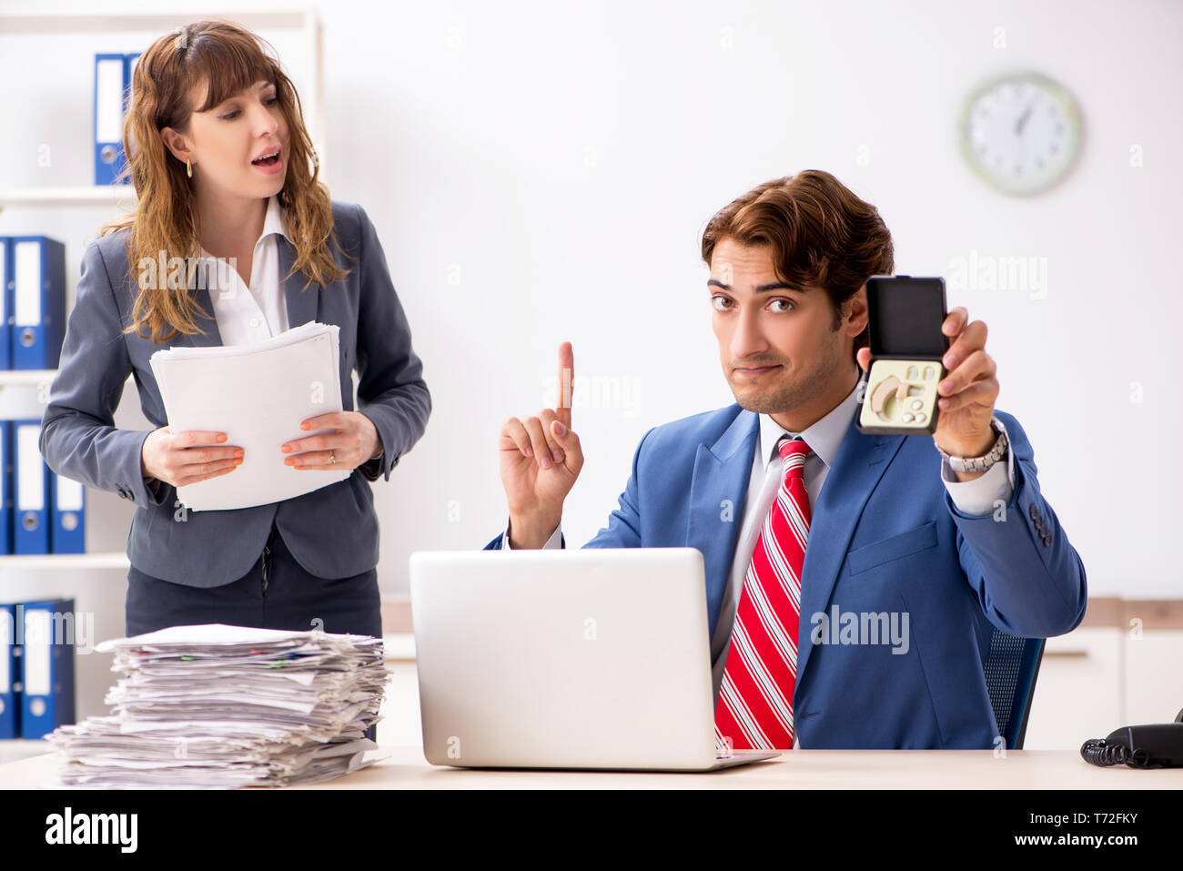 Deaf employee using hearing aid talking to boss Stock Photo - Alamy