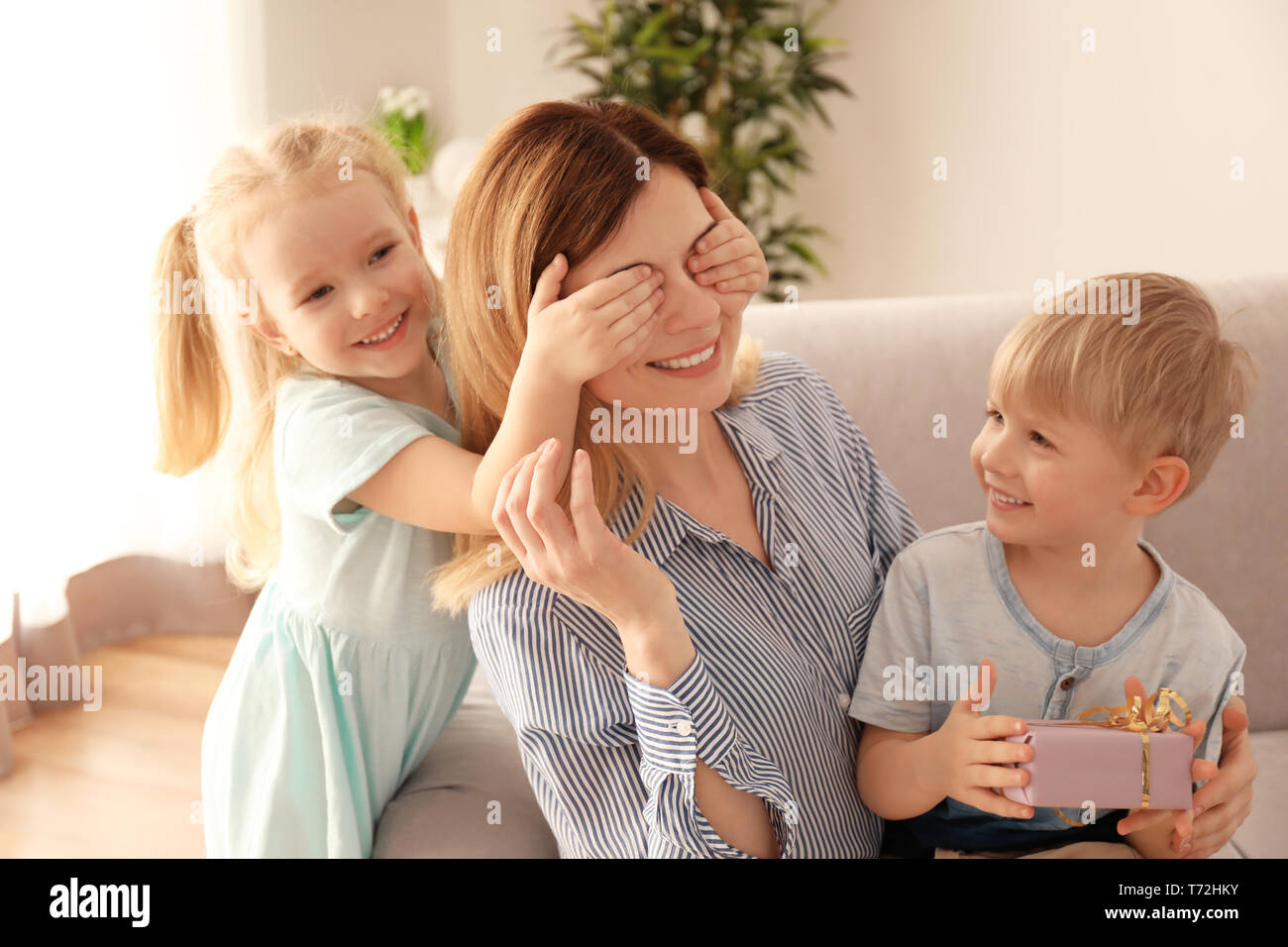 Cute little children greeting their mother at home Stock Photo - Alamy