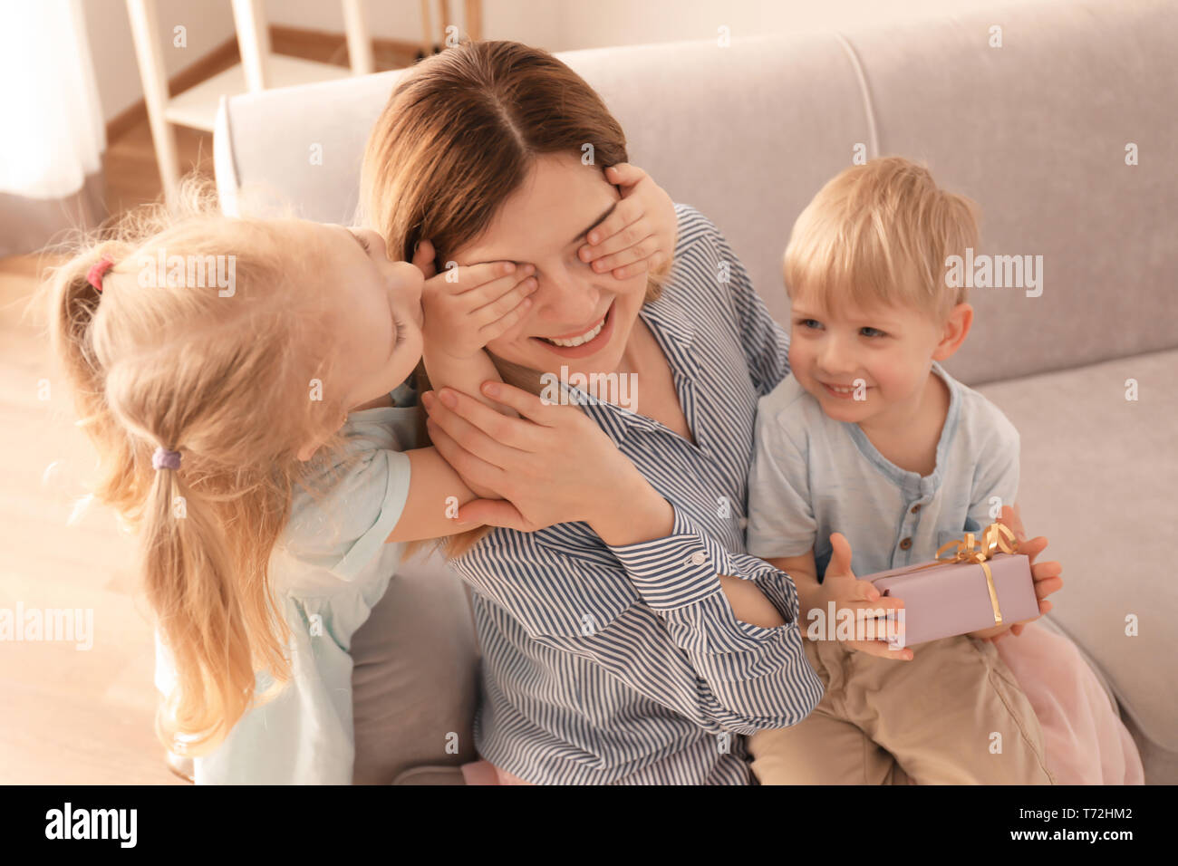 Cute little children greeting their mother at home Stock Photo - Alamy