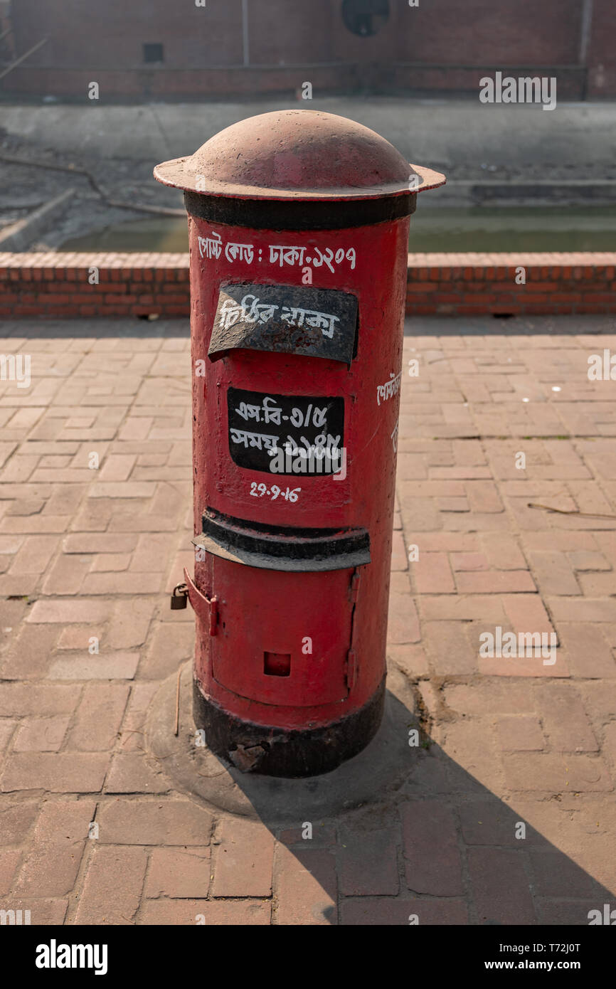 Red mailbox on the street in Dhaka, Bangladesh with writing in Bengali ...