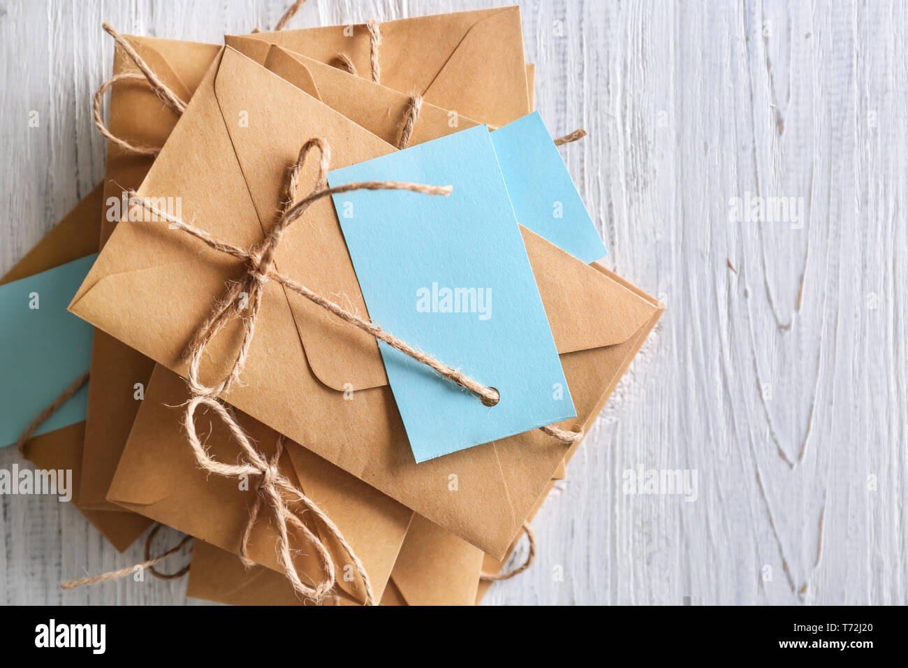 Brown envelopes with tags on wooden background, top view. Mail service ...