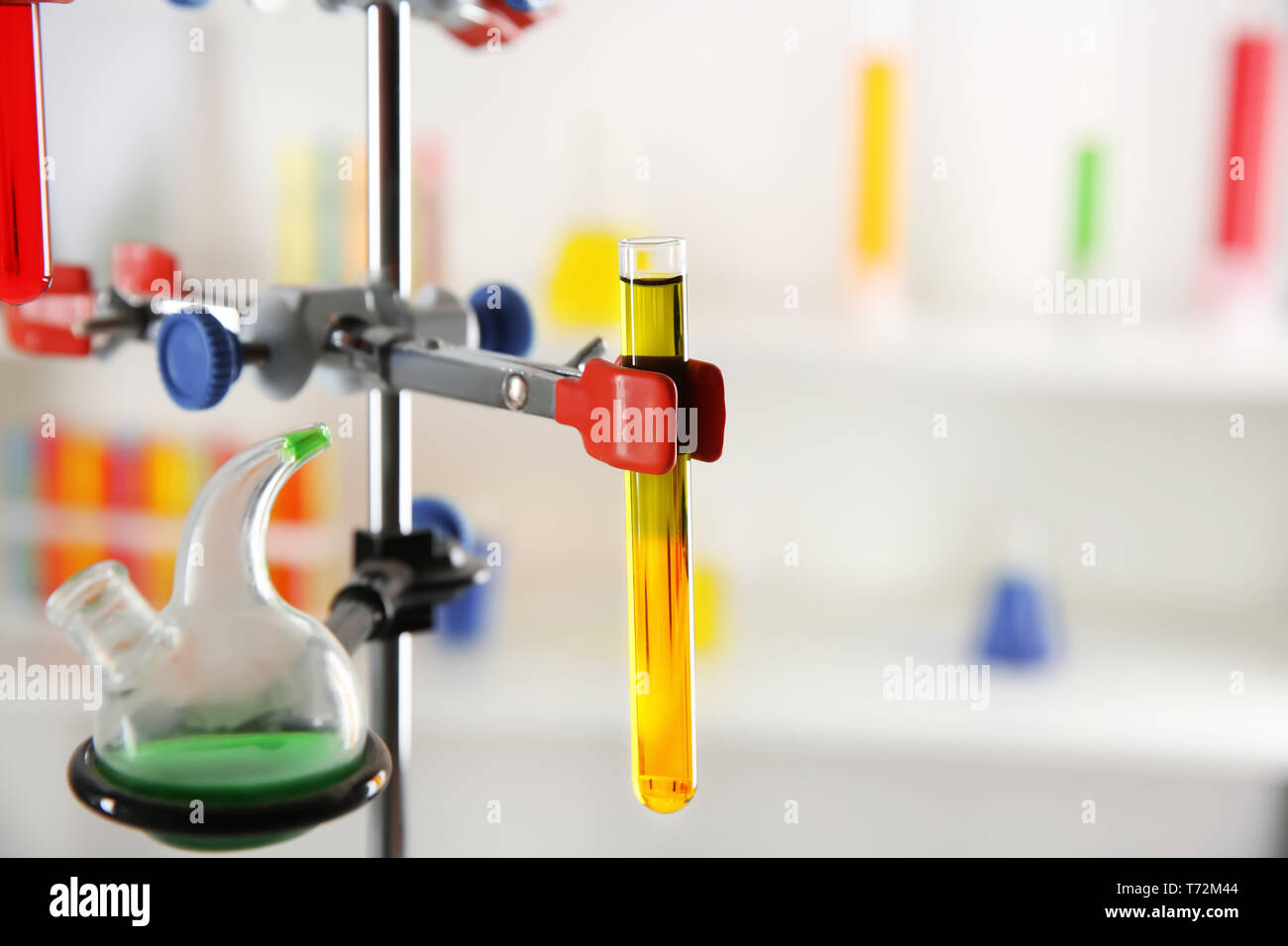 Stand with test tube and laboratory glassware against blurred ...