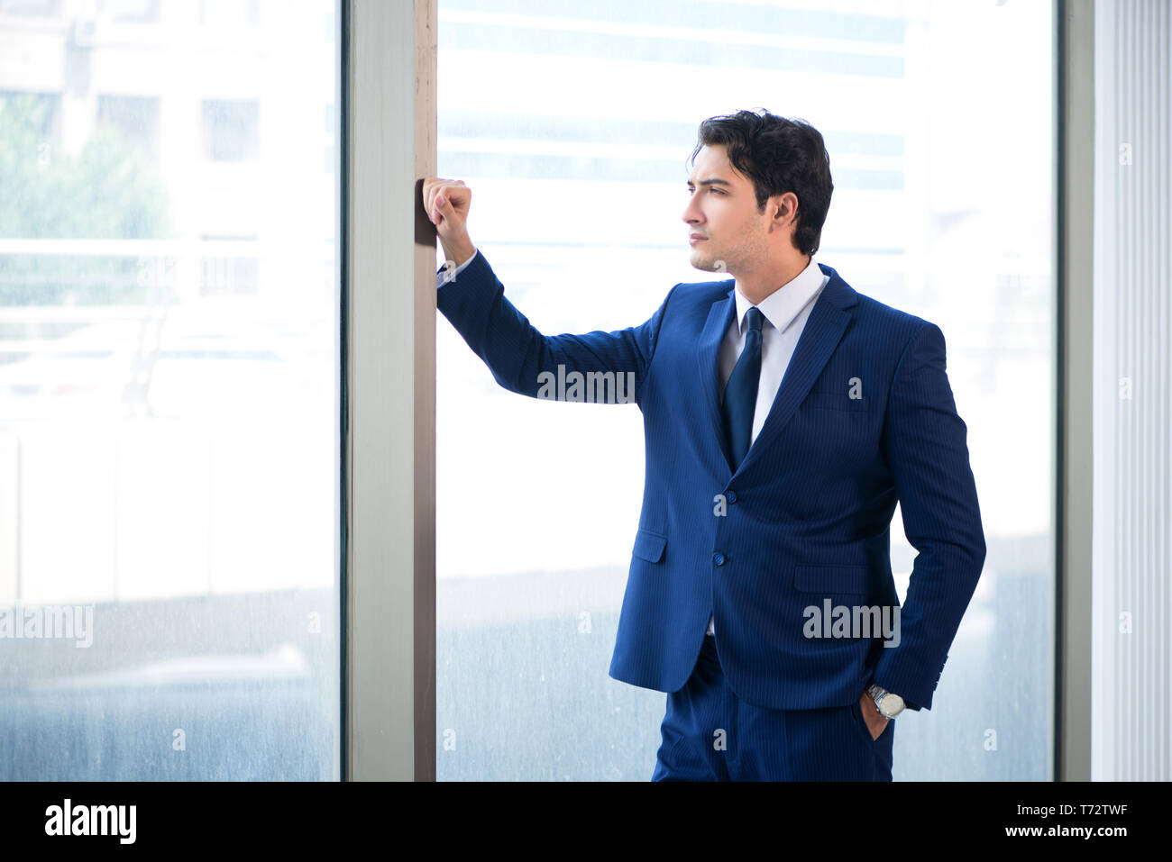 Young handsome businessman standing at the window Stock Photo - Alamy