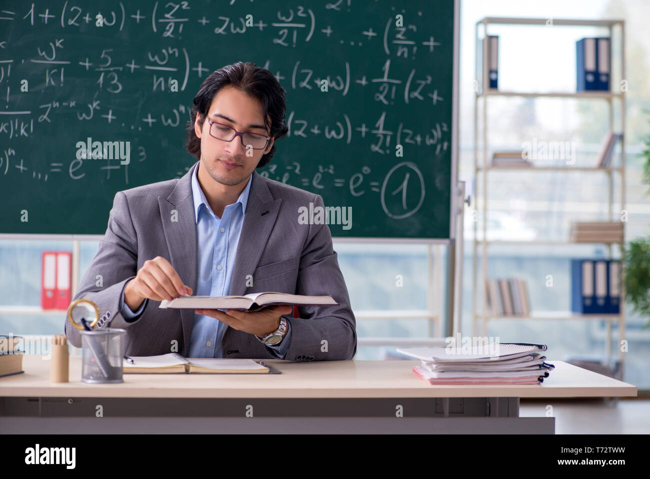 Young handsome math teacher in classroom Stock Photo - Alamy