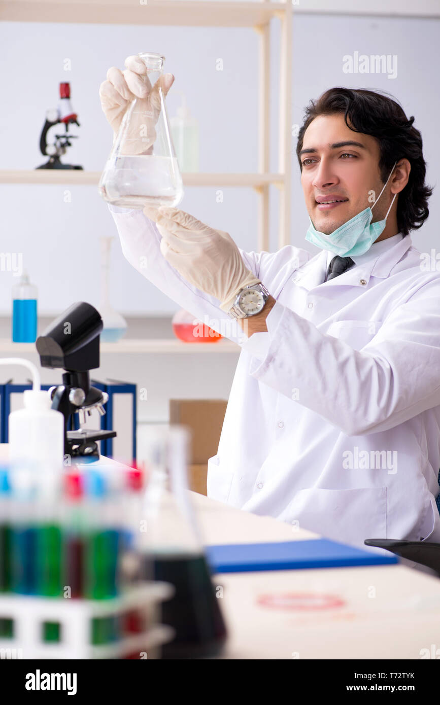 Young handsome chemist working in the lab Stock Photo - Alamy