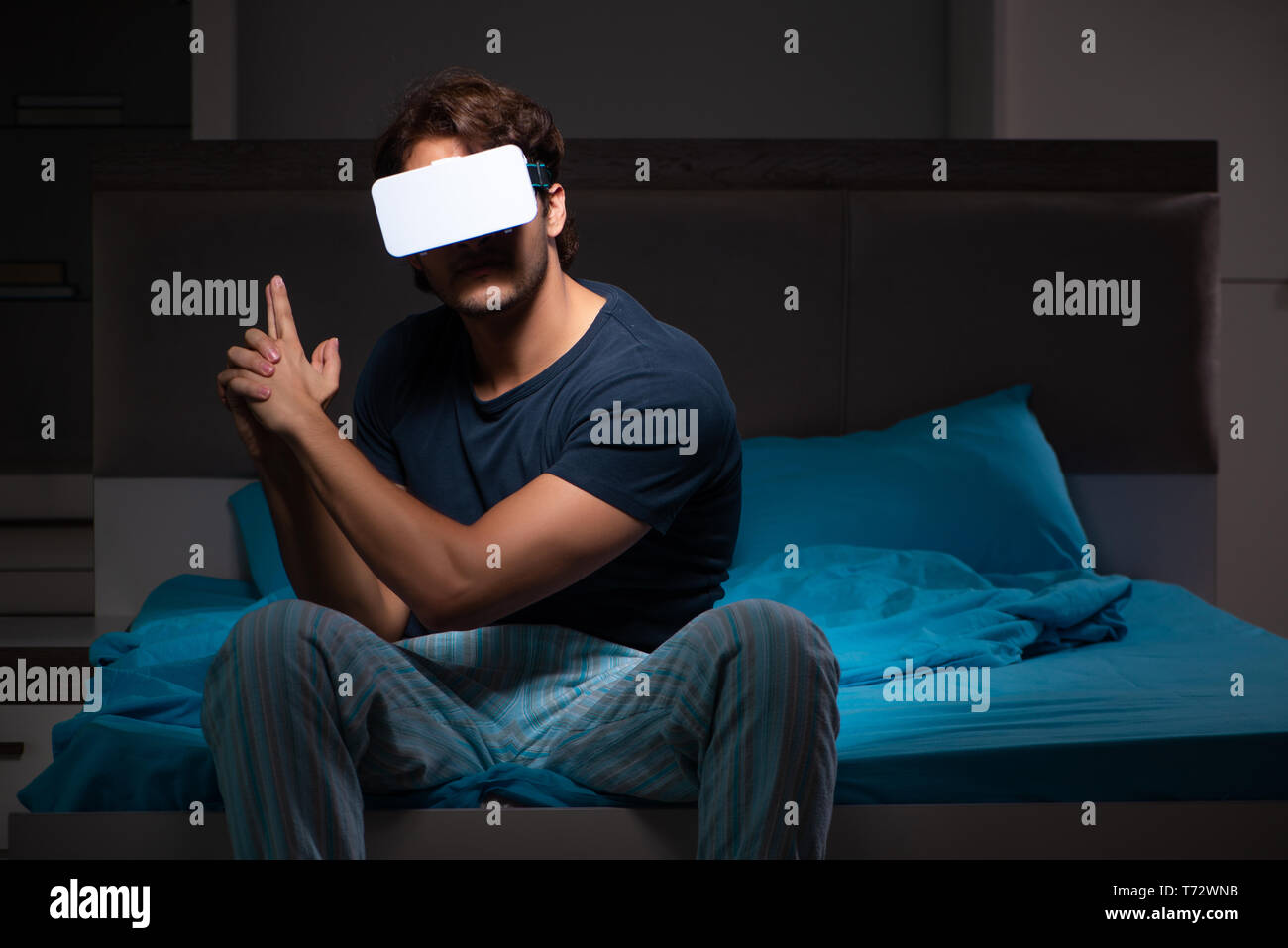 Young man playing computer games at night in bed Stock Photo - Alamy