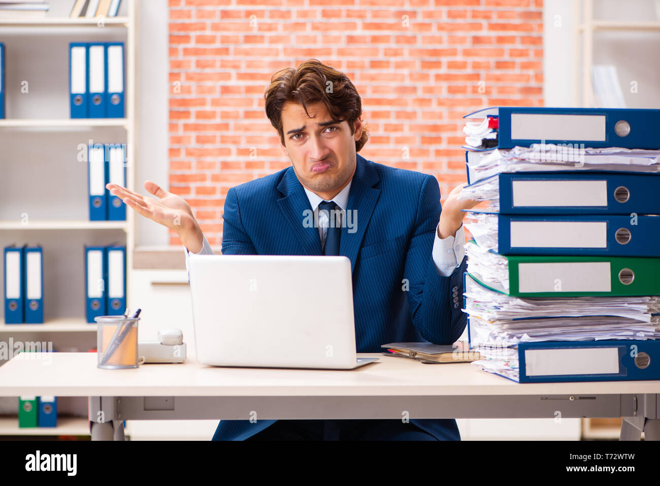 Young elegant man unhappy with too much work Stock Photo - Alamy