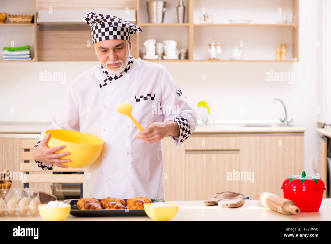 Old male baker working in the kitchen Stock Photo - Alamy