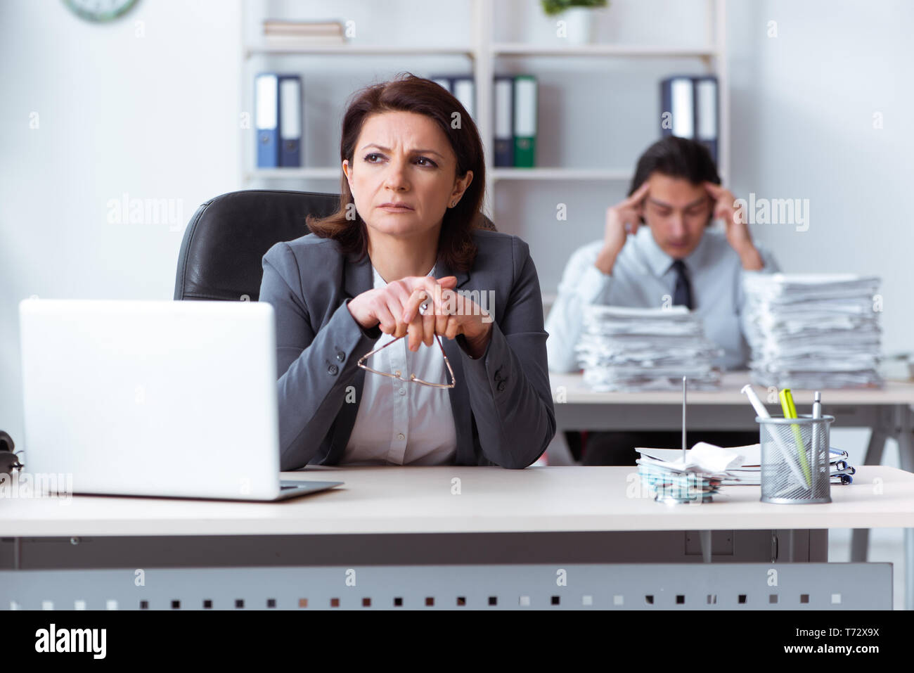 Old female boss and young male employee in the office Stock Photo - Alamy