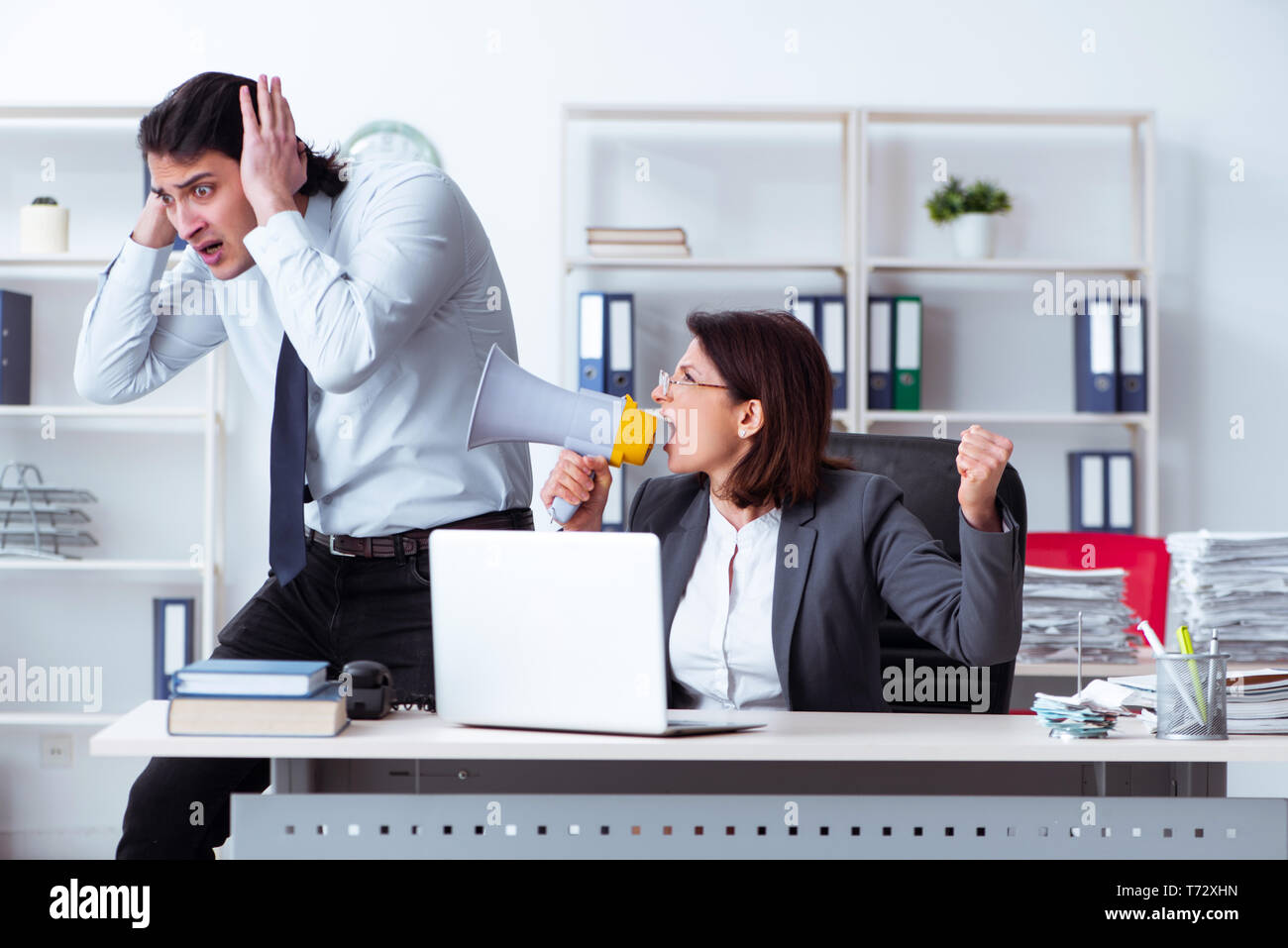 Old female boss and young male employee in the office Stock Photo - Alamy