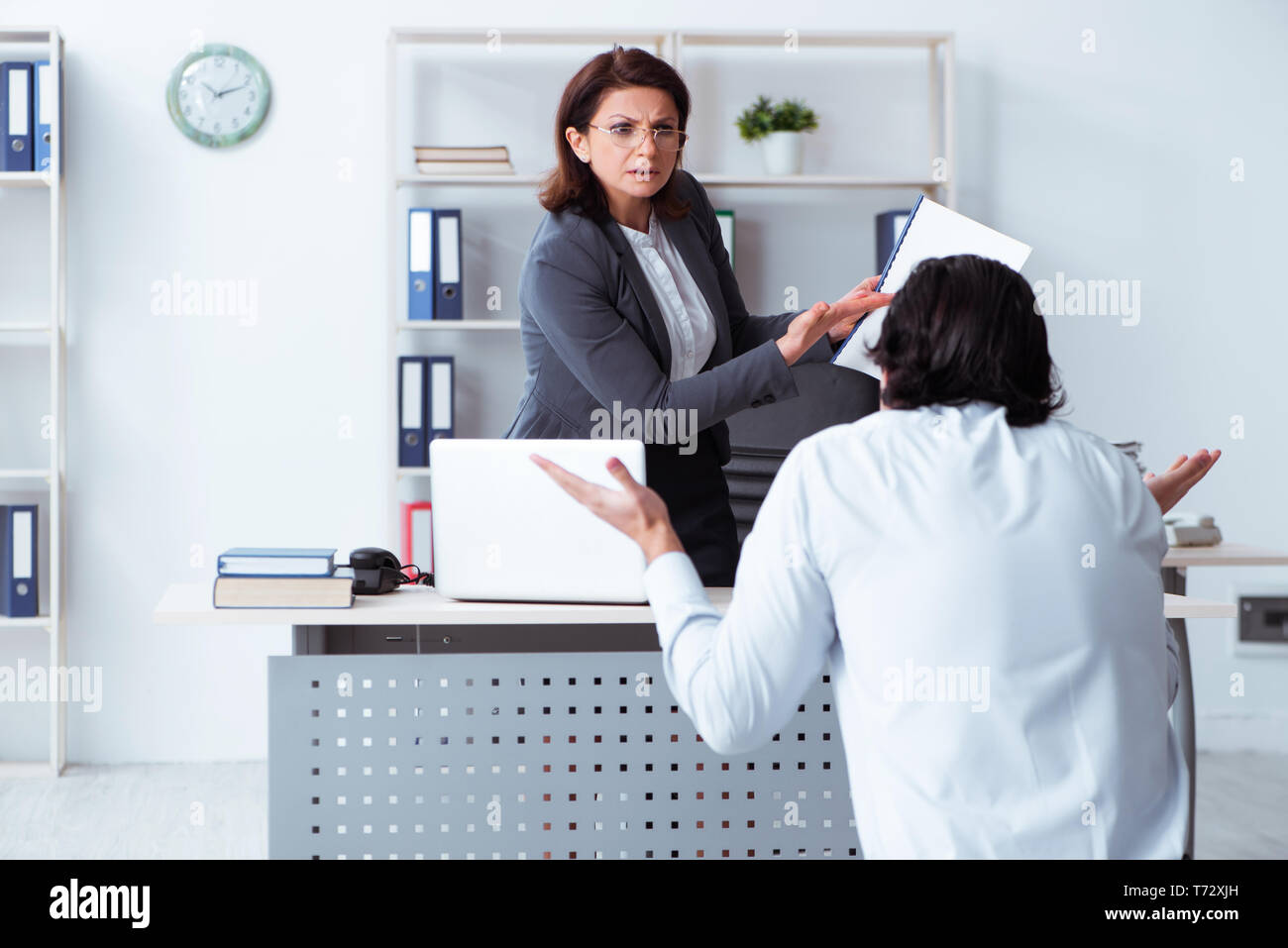 Old female boss and young male employee in the office Stock Photo - Alamy