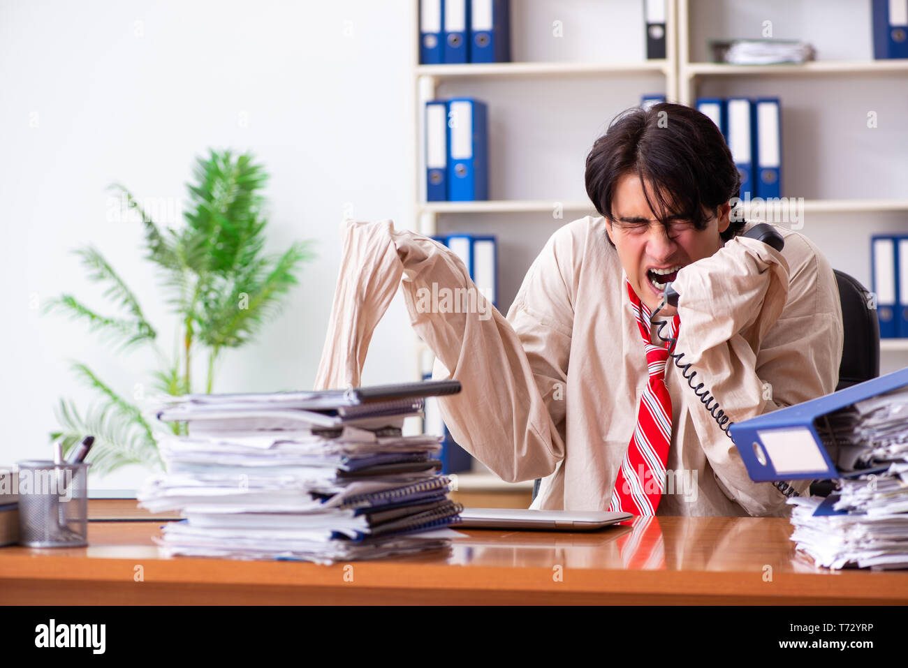 Crazy young man in straitjacket at the office Stock Photo - Alamy