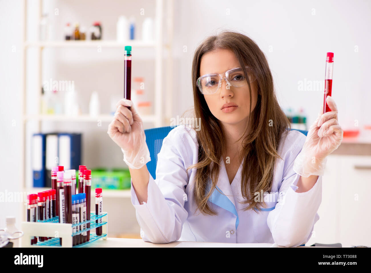 Young beautiful lab assistant testing blood samples Stock Photo - Alamy