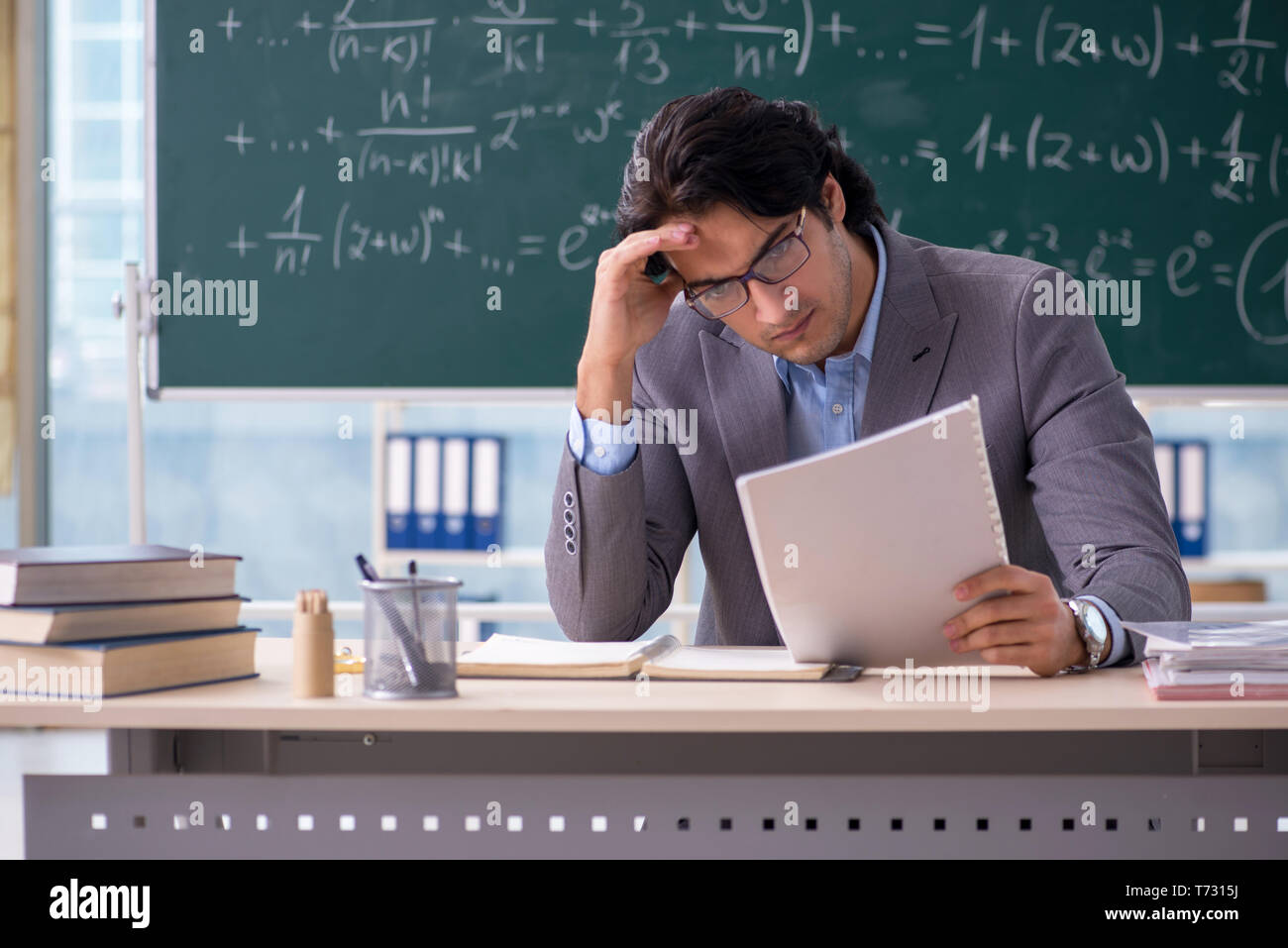 Young handsome math teacher in classroom Stock Photo - Alamy