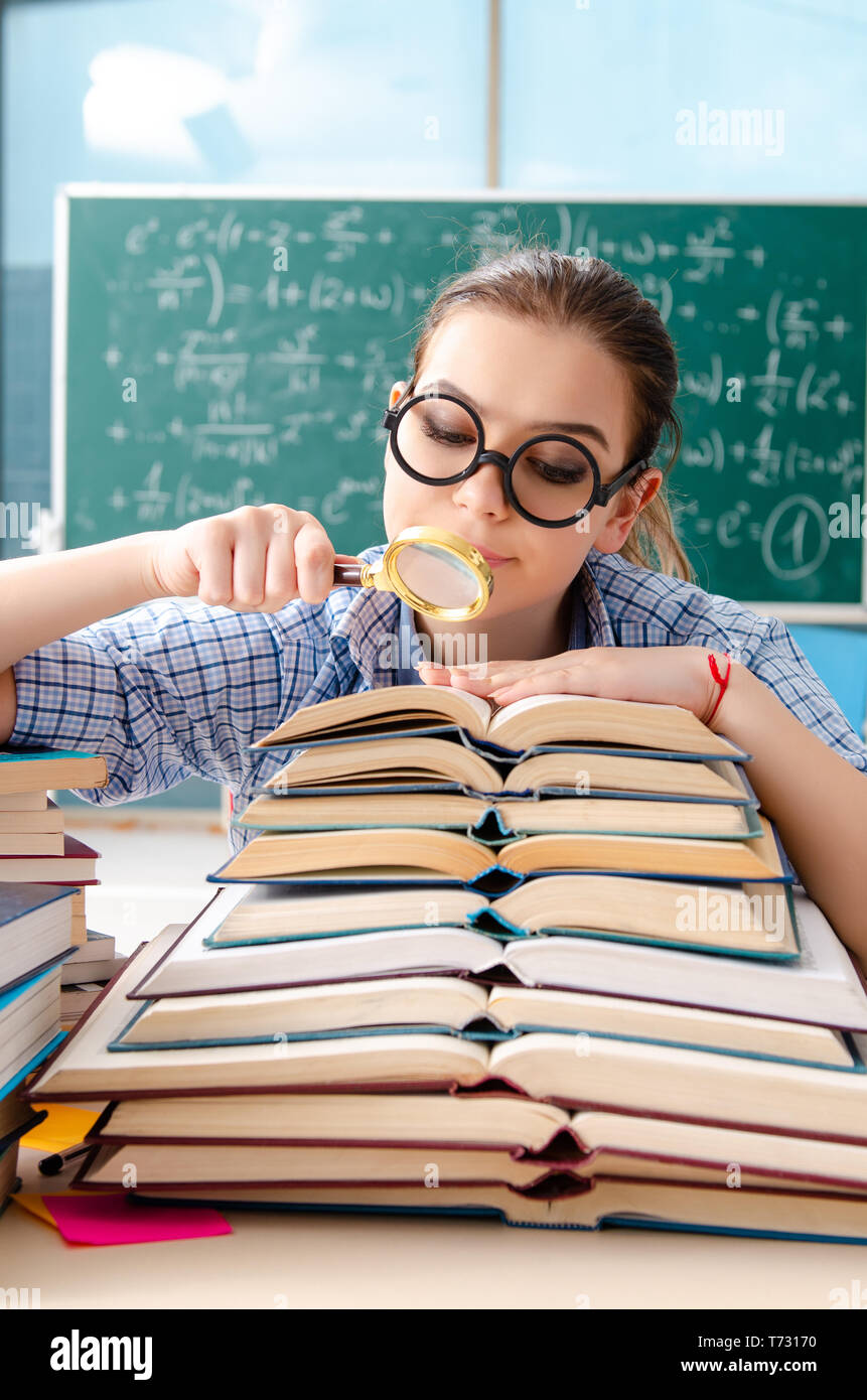 Female student with many books sitting in the classroom Stock Photo - Alamy