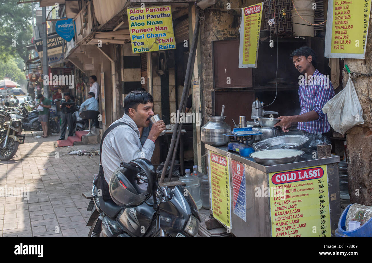 A man selling Lassi, an traditional Indian yoghurt drink, at a street ...