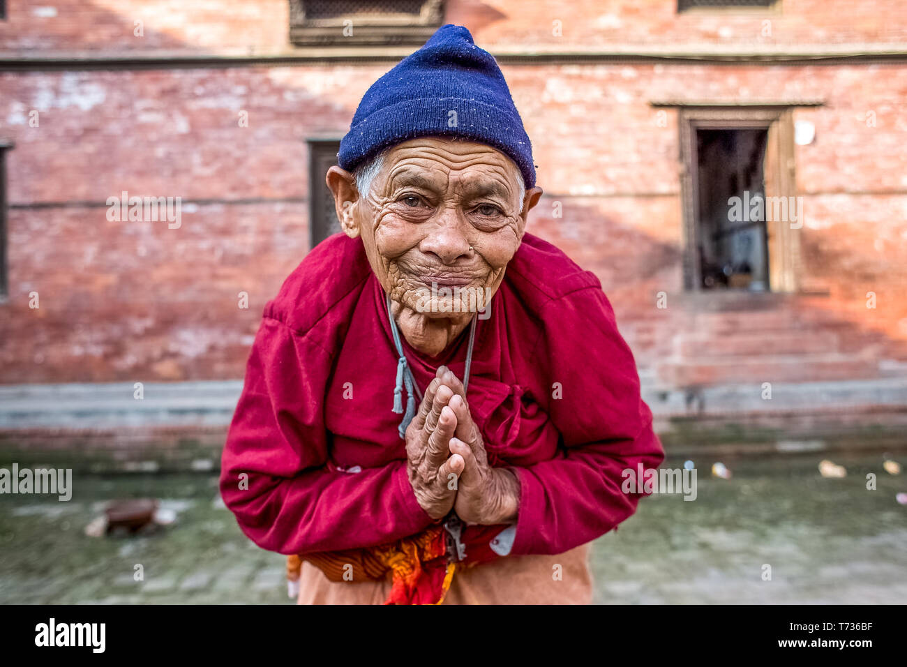 Life after the earthquake. Elderly woman expresses Pranam (Hindu way of ...