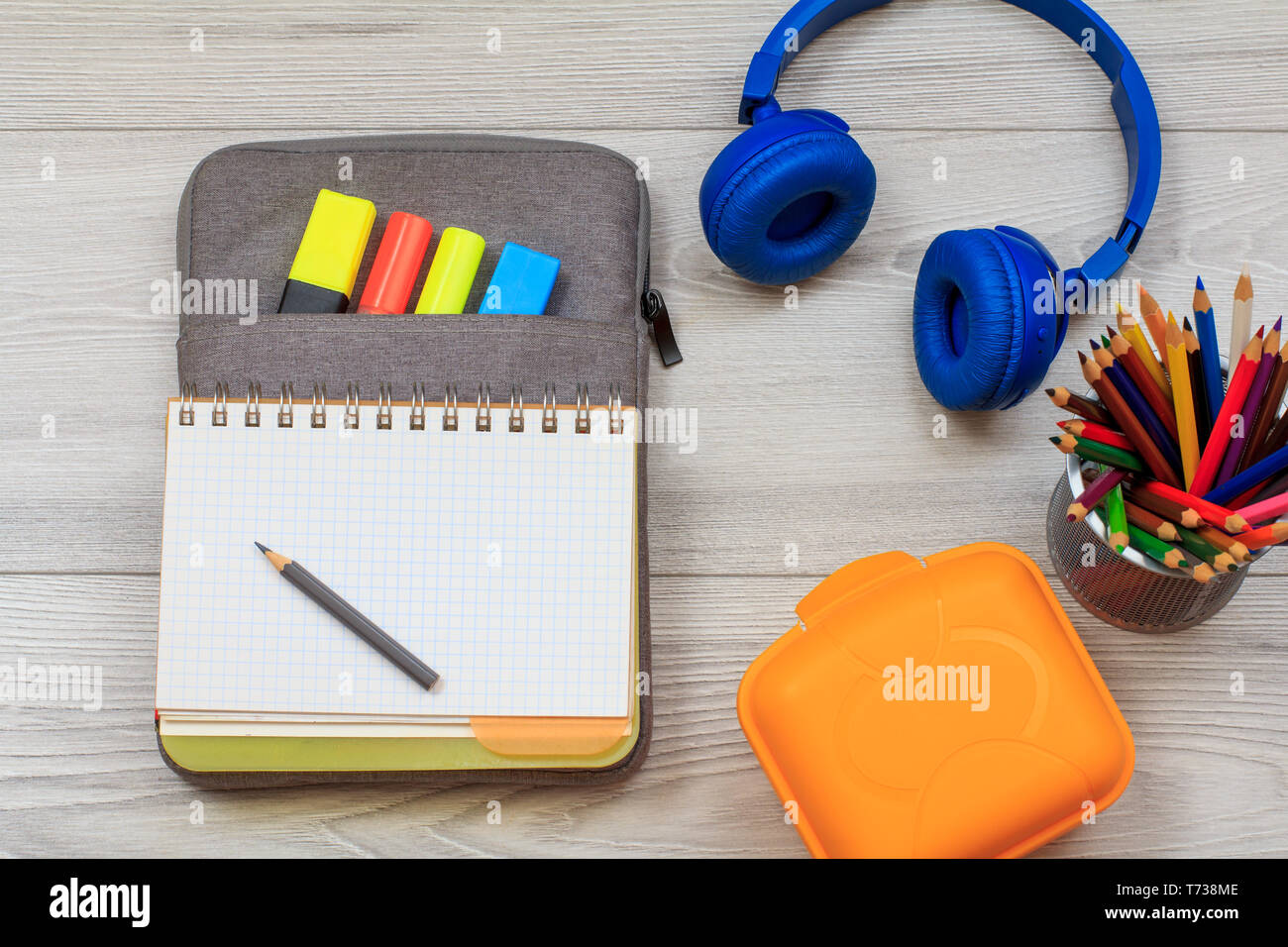 Open exercise book on bag-pencil case with color felt pens and marker ...