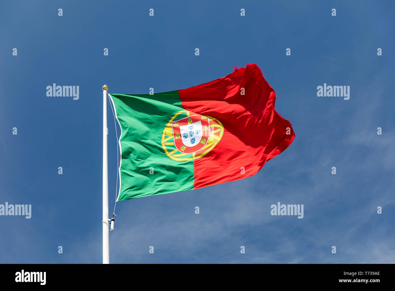 Beautiful large Portuguese flag waving in the wind against blue sky ...
