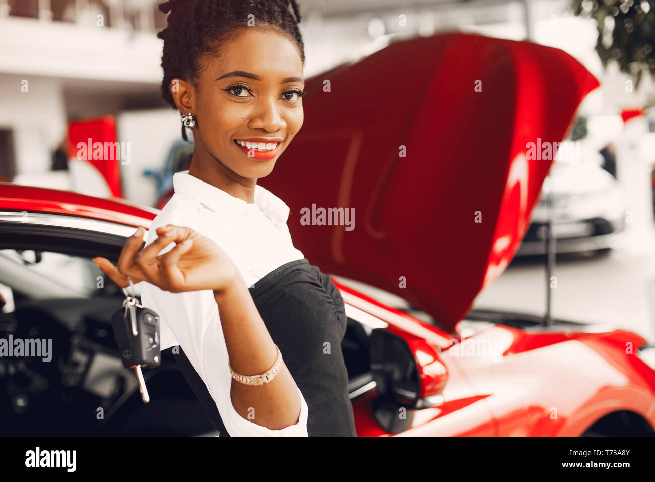 Woman buying the car. Lady in a car salon. Elegant black girl Stock ...