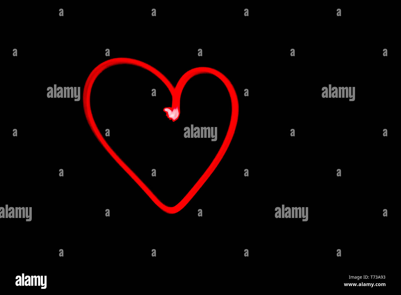 horizontal view of a red heart outline light painting in black night ...