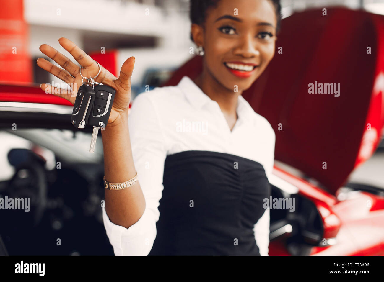 Woman buying the car. Lady in a car salon. Elegant black girl Stock ...