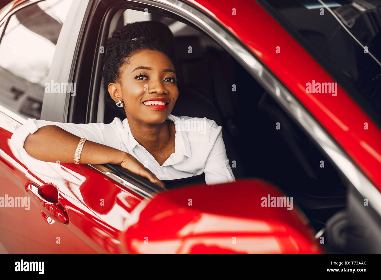Woman buying the car. Lady in a car salon. Elegant black girl Stock ...
