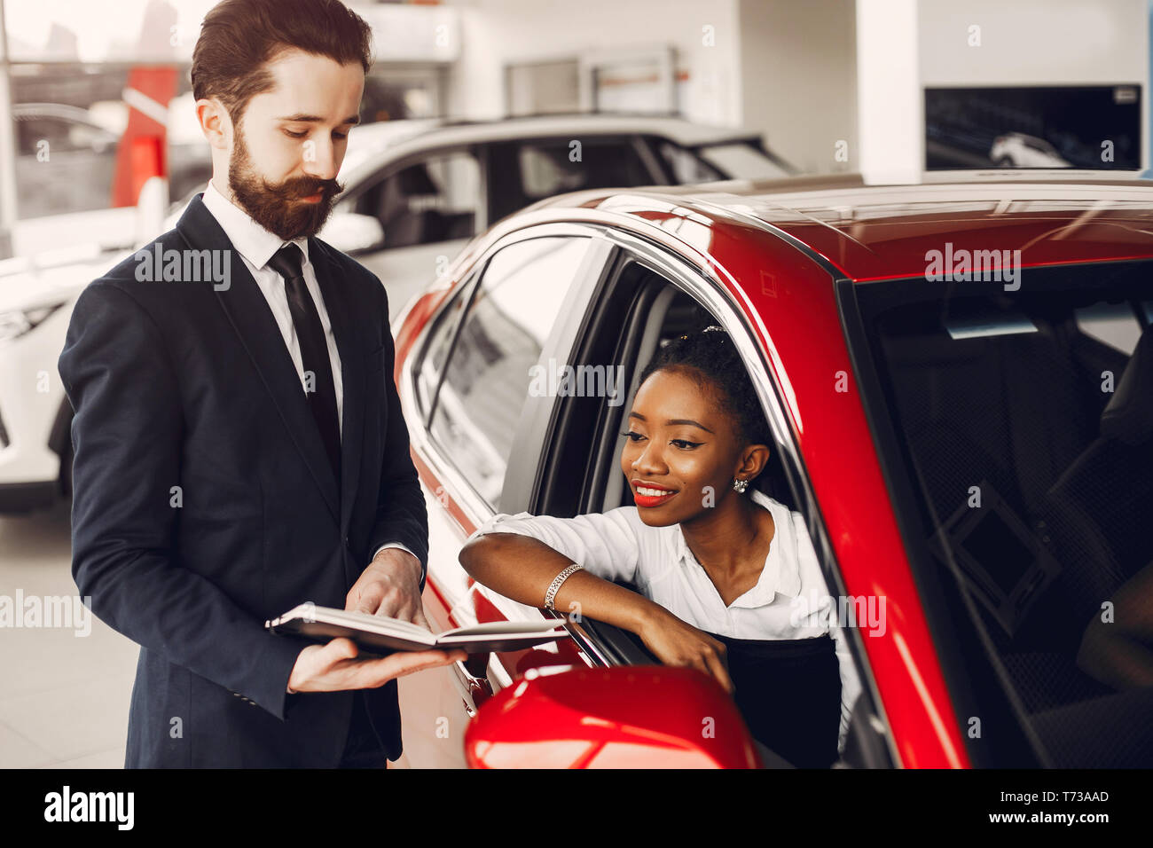 Woman buying the car. Lady in a car salon. Manager with a clients Stock ...