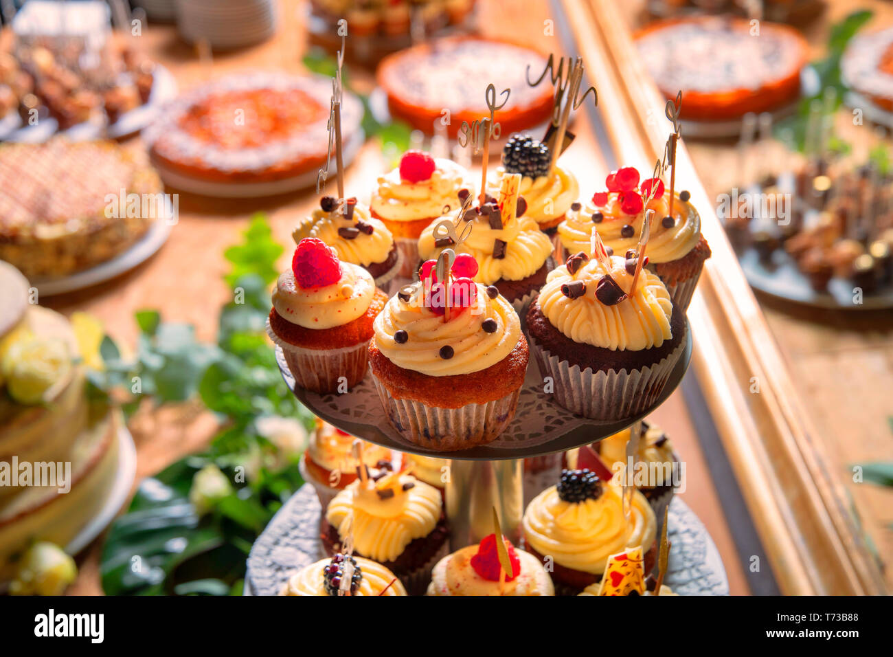 sweet table at a wedding with sweet muffins cream filling and garnished ...
