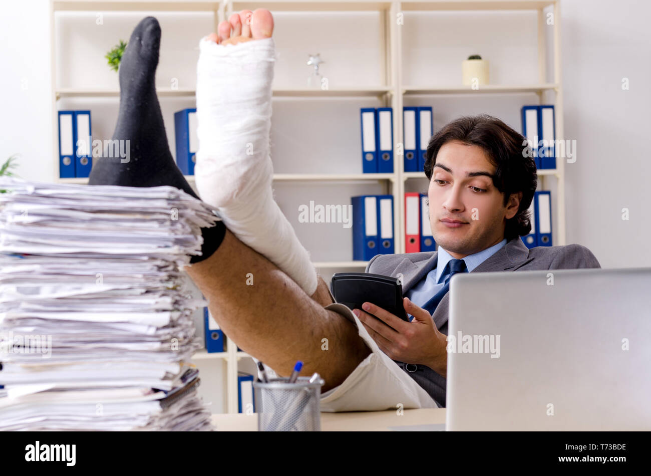 Leg injured employee working in the office Stock Photo - Alamy