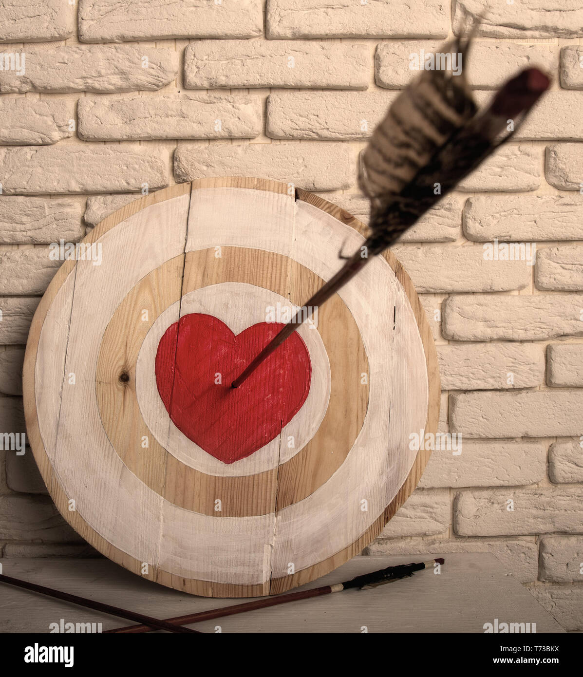 Handmade rough wooden target with a center in the form of a red heart ...