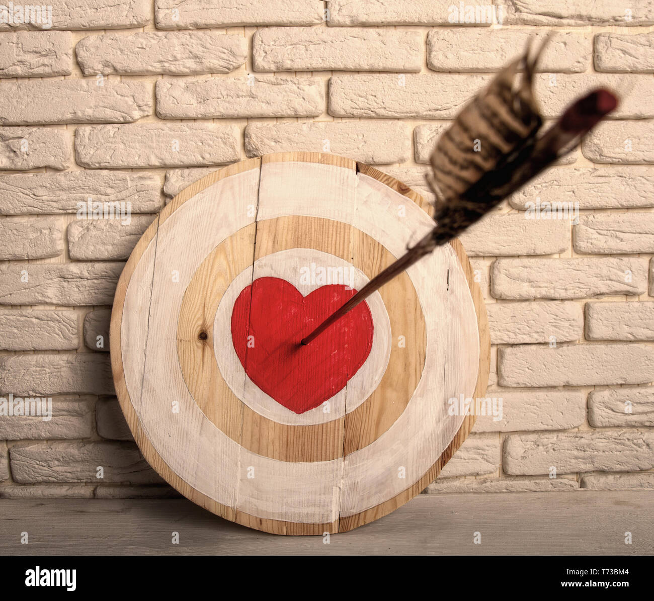 Handmade rough wooden target with a center in the form of a red heart ...