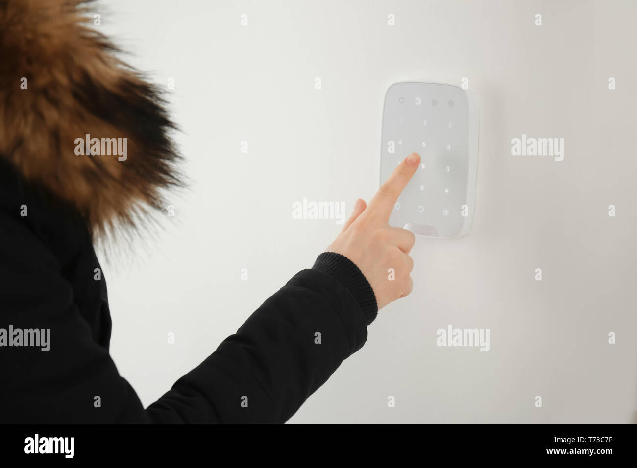 Woman using security system indoors Stock Photo - Alamy
