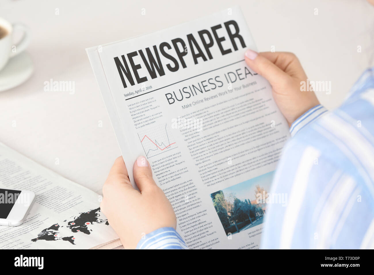 Woman reading morning newspaper indoors Stock Photo - Alamy