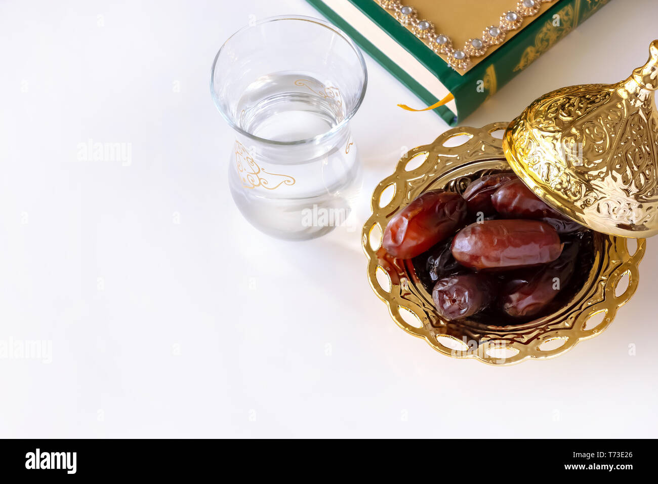 Organic dried dates in traditional arabic golden plate, cup of pure ...