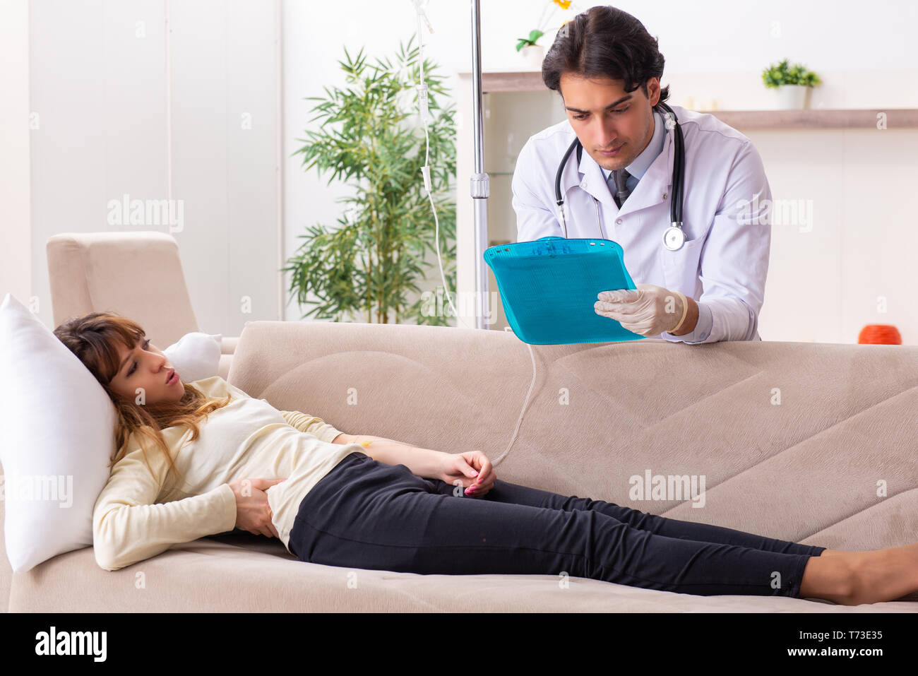 Young handsome doctor visiting female patient at home Stock Photo - Alamy