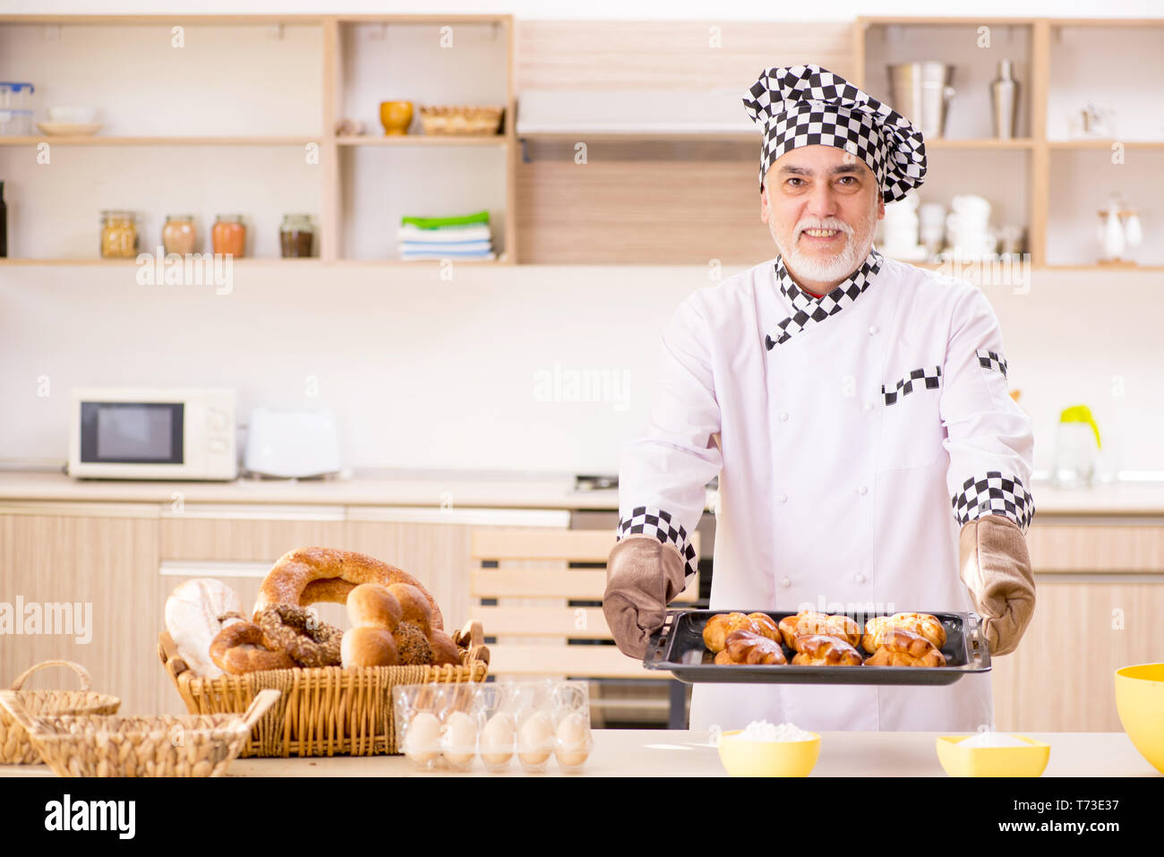 Old male baker working in the kitchen Stock Photo - Alamy