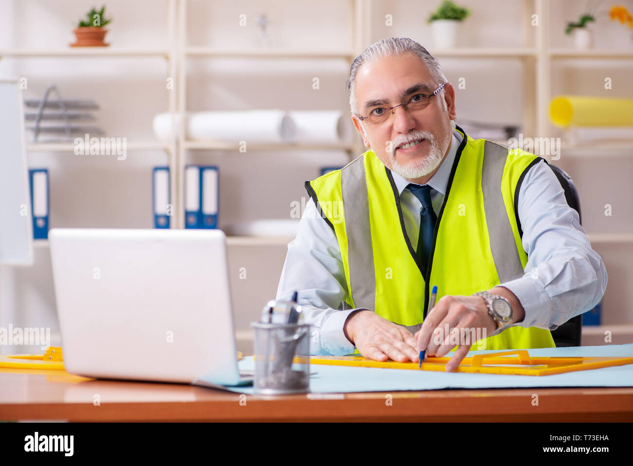 Aged construction engineer working in the office Stock Photo - Alamy