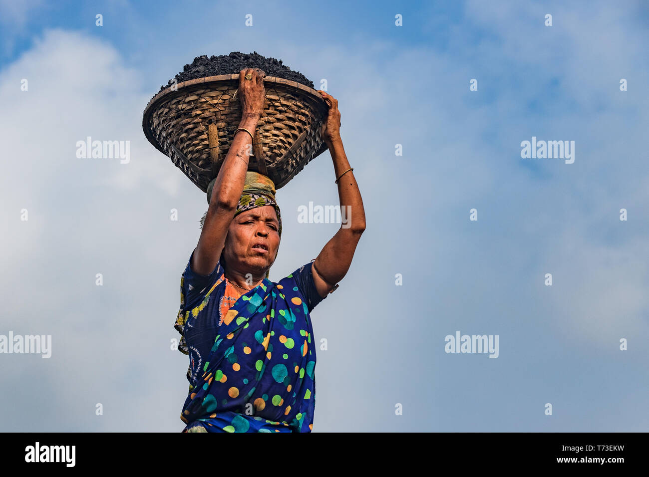 Male & Female dock workers are seen as they unload coal with bamboo ...