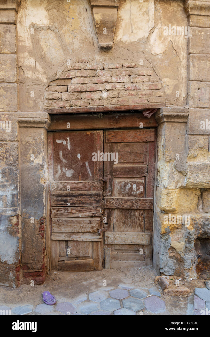 Broken wooden door on grunge stone bricks wall in abandoned Darb El ...