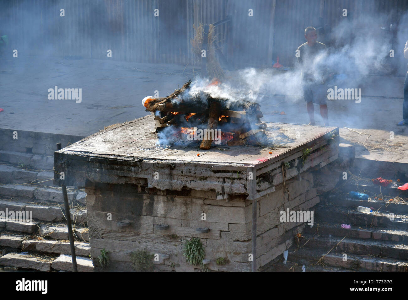 Hindu cremation process in progress near a temple Pashupatinath ...