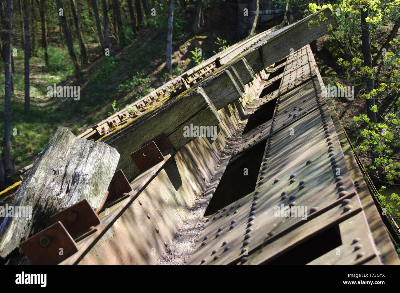 A collapsed railway bridge over the river. Ruins from the period of ...