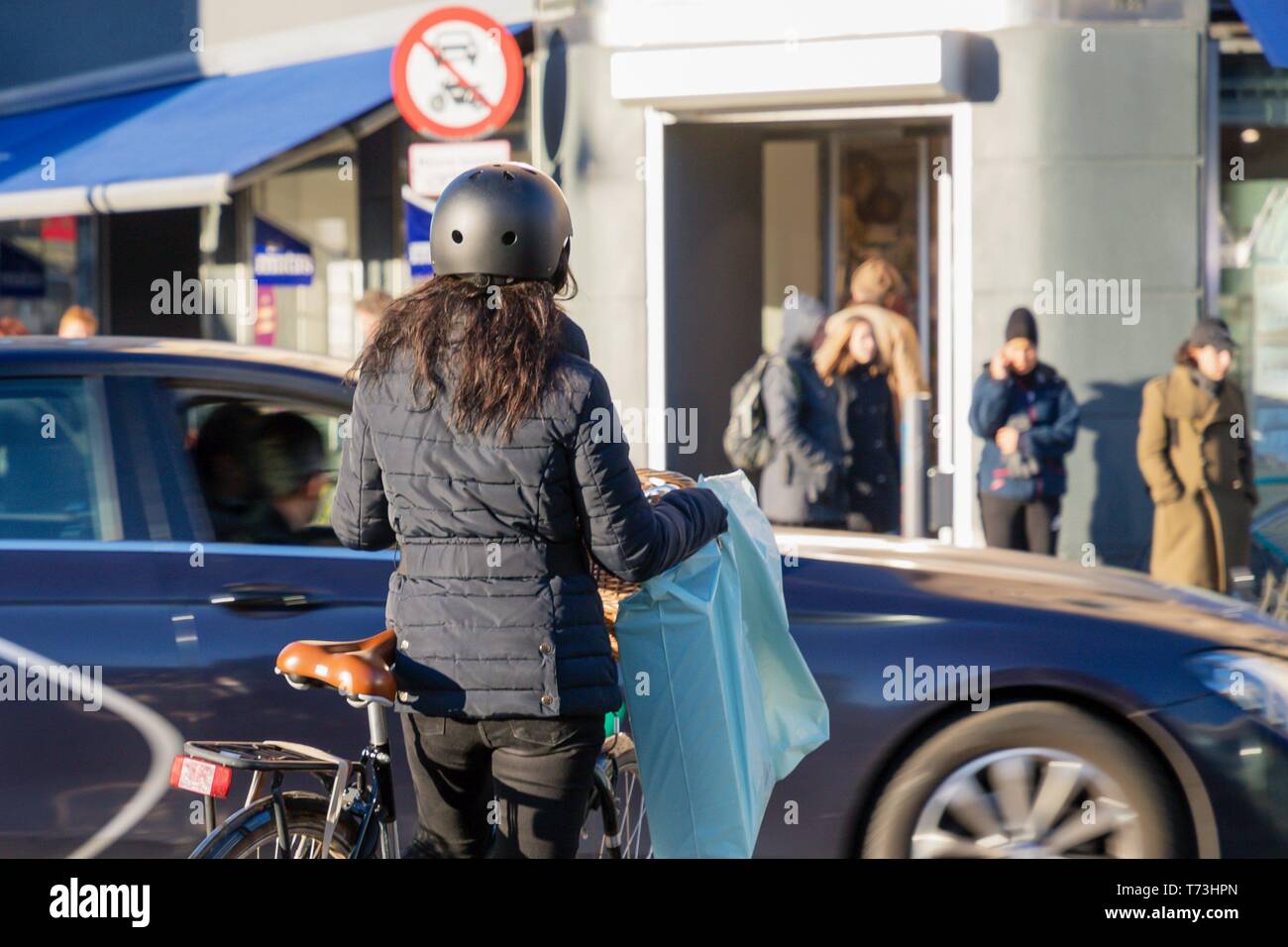 Female cyclist waiting for traffic lights on city center Stock Photo ...
