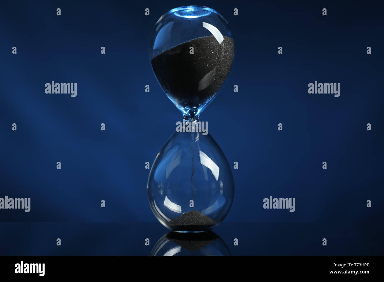 Hourglass on color dark background. Time management concept Stock Photo ...