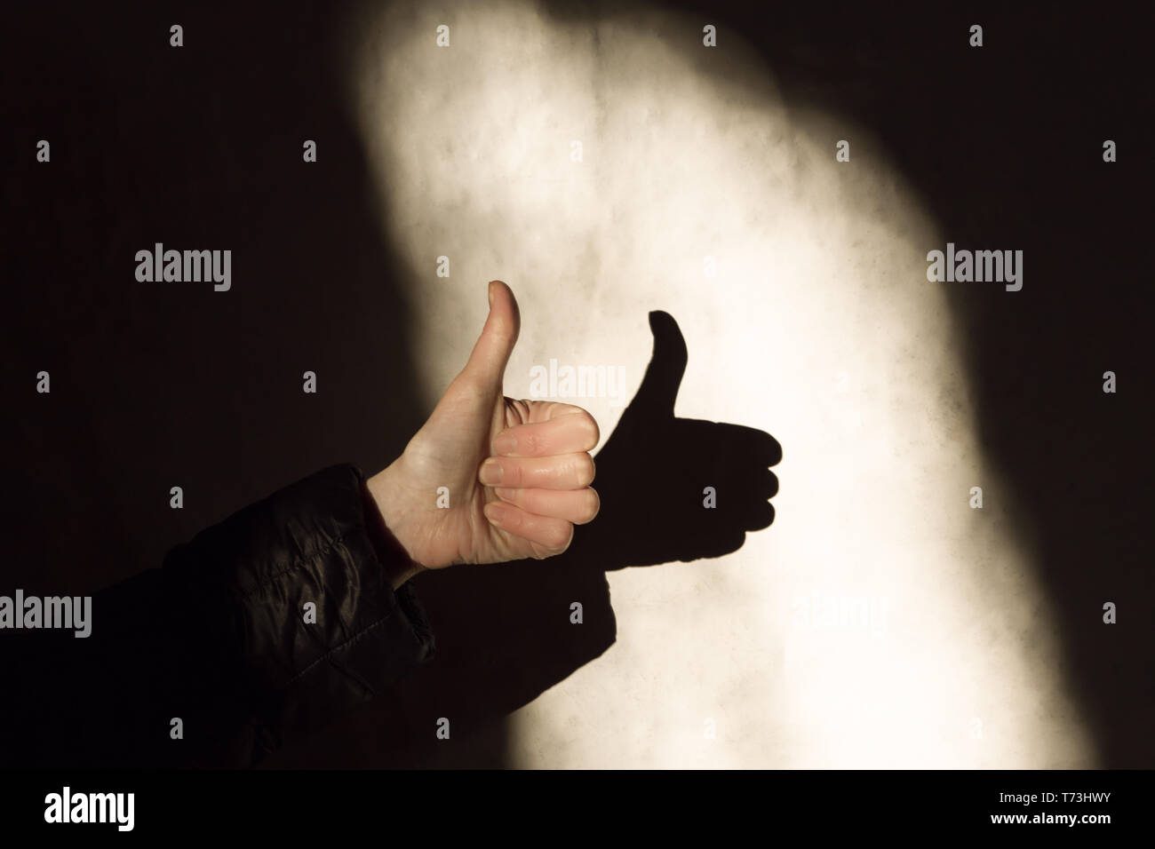 Woman hand thump up sign or like symbol and shadow on a wall Stock ...