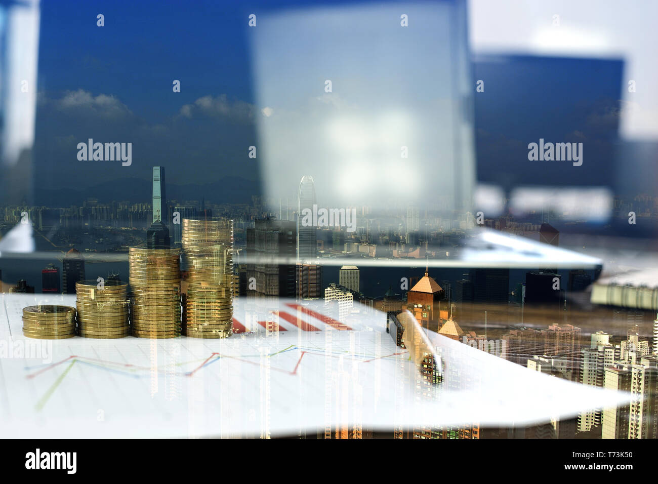 Double exposure of coins stacks with notebook computer and financial ...