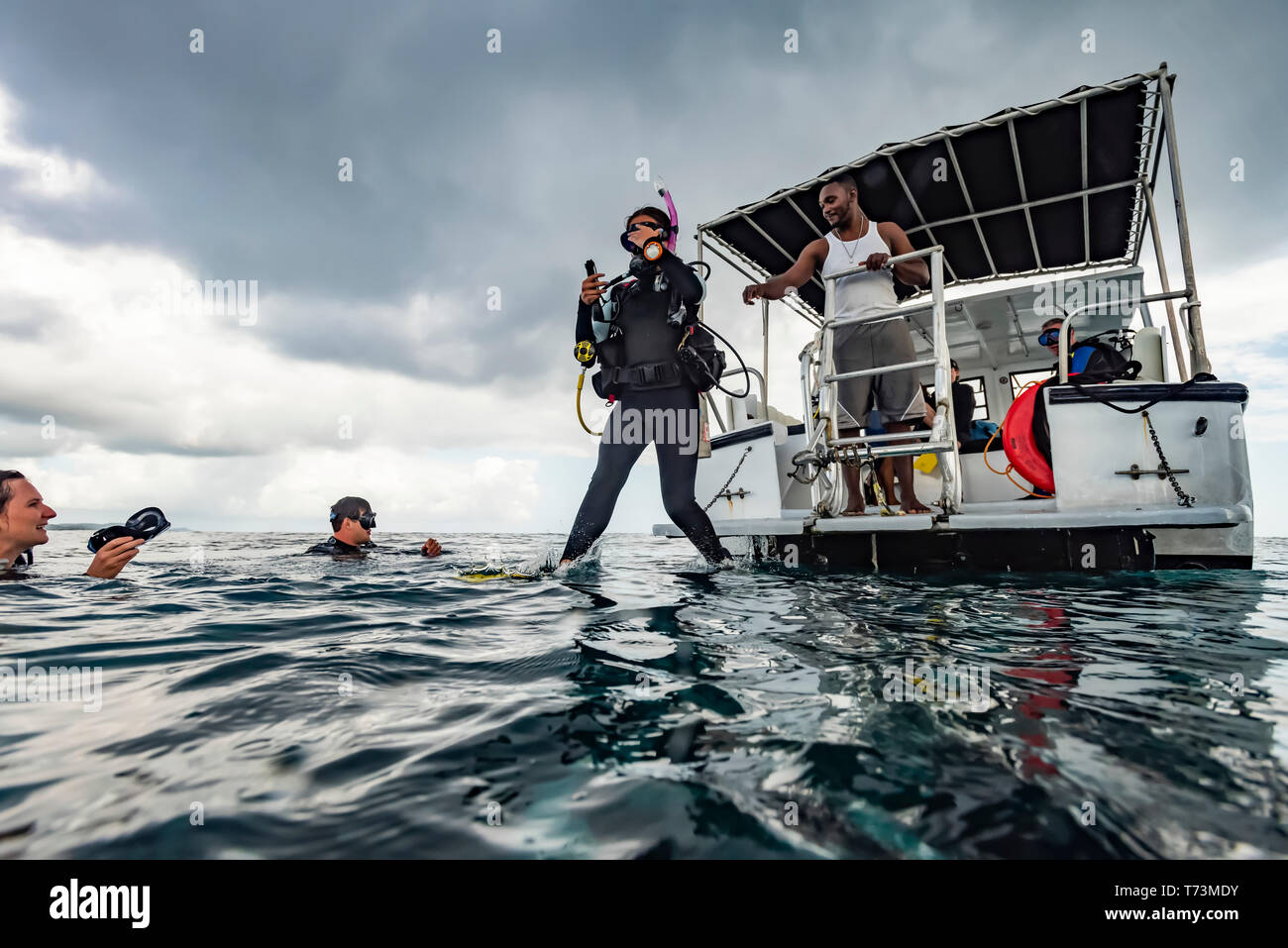 Scuba divers enter the water from a boat for their tour of the Cemetery ...