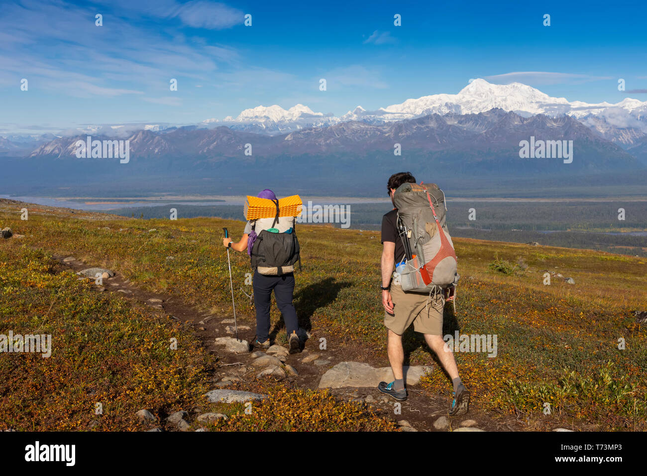 Woman and man backpacking on the tundra towards Denali and the Alaska ...