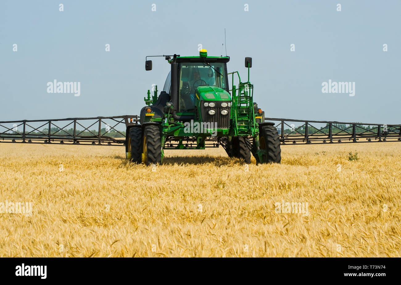 A high clearance sprayer gives a ground chemical application of ...